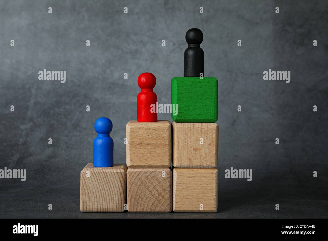Stair made of wooden cubes as way to goal. Figures on different blocks ...