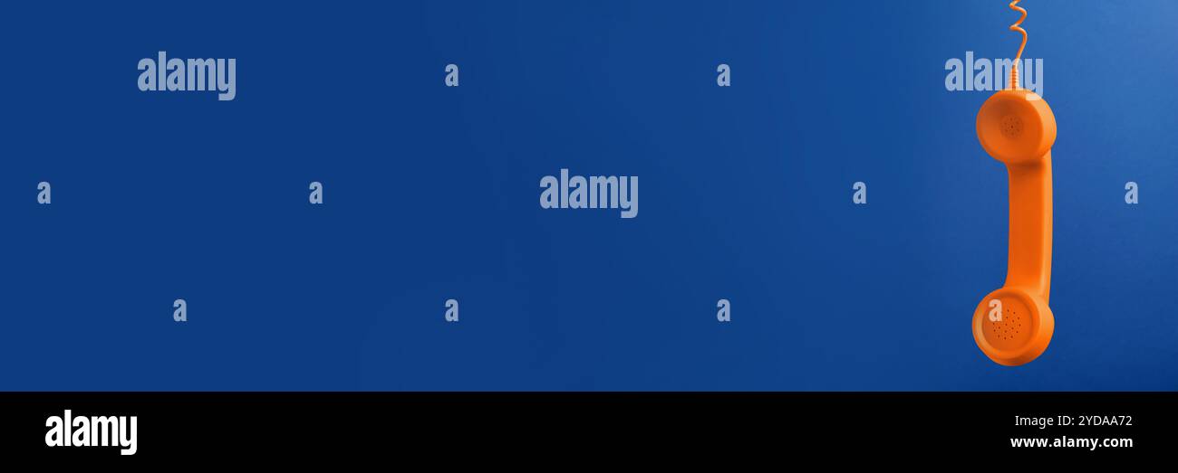 Orange corded telephone handset on blue background. Banner design with ...