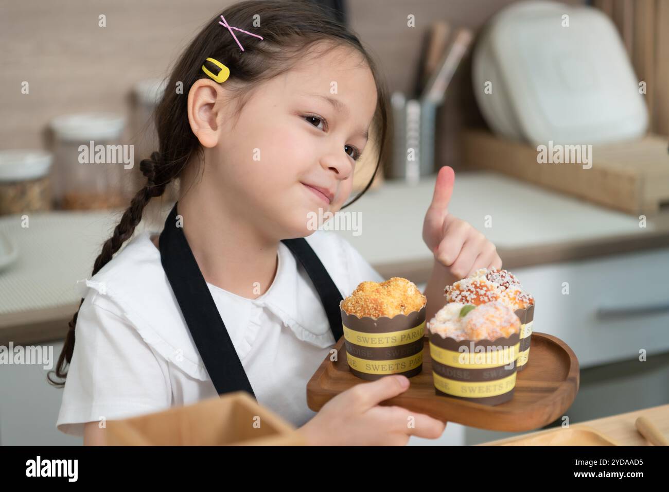 Portrait of a little girl in the kitchen of a house having fun playing ...