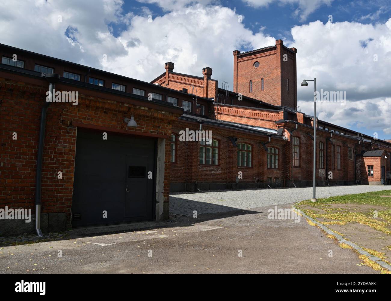 A historic brick industrial building with large arched windows and a ...