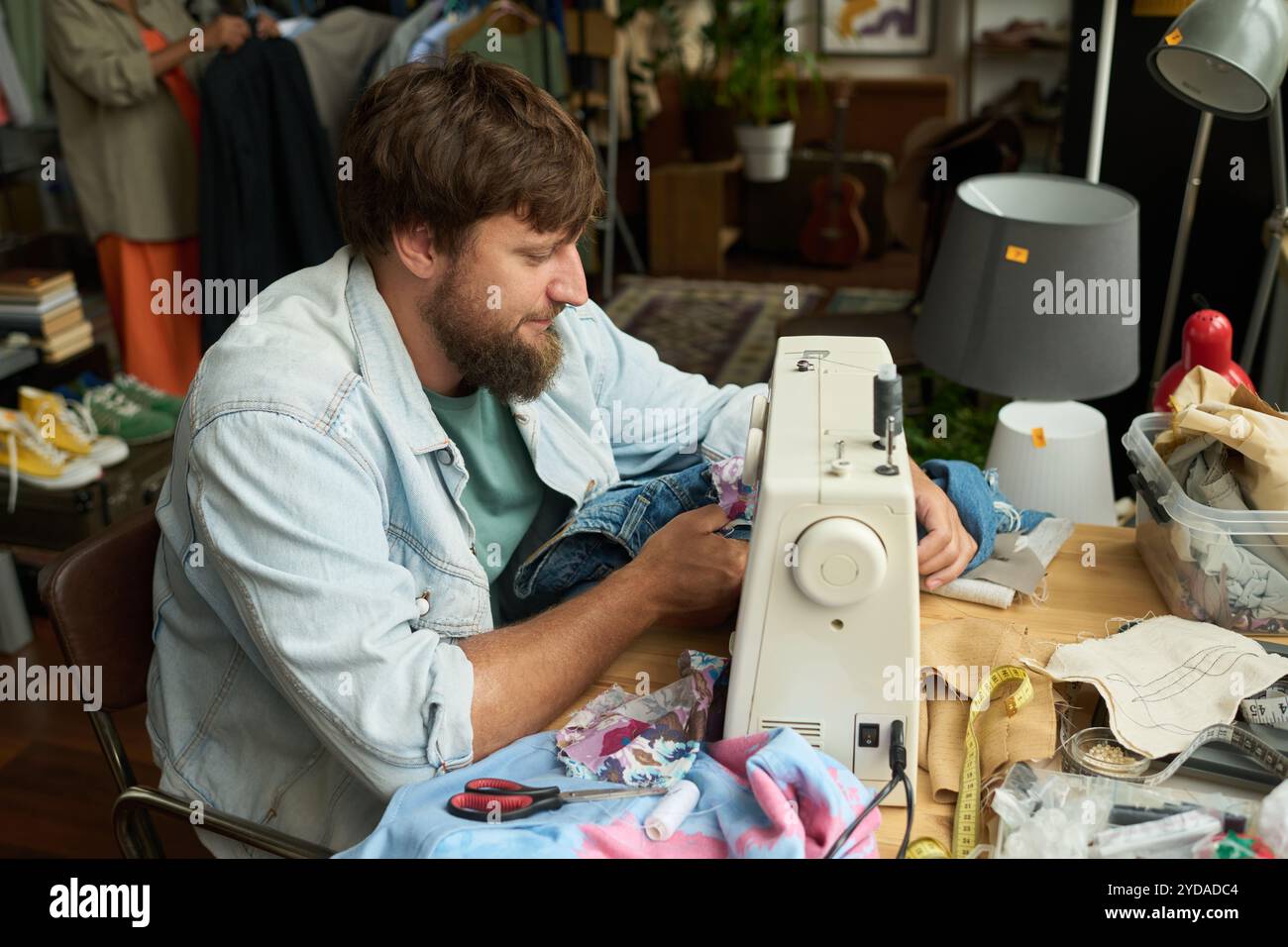 bearded male owner of modern thrift shop upcycling used denim jacket ...