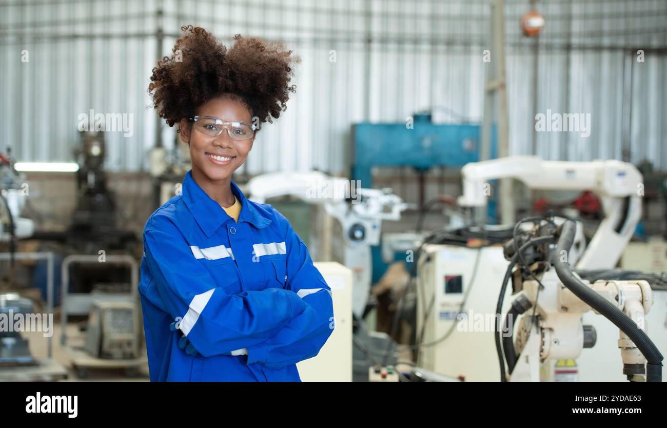 Young female engineers are manipulating a welding robot hand. By ...