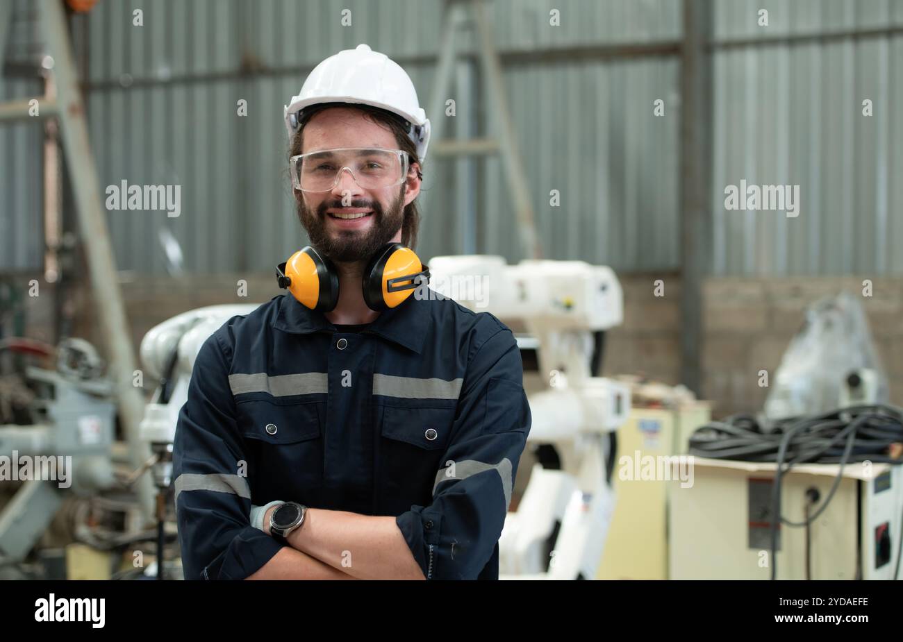 Young male engineers are manipulating a welding robot hand. By ...