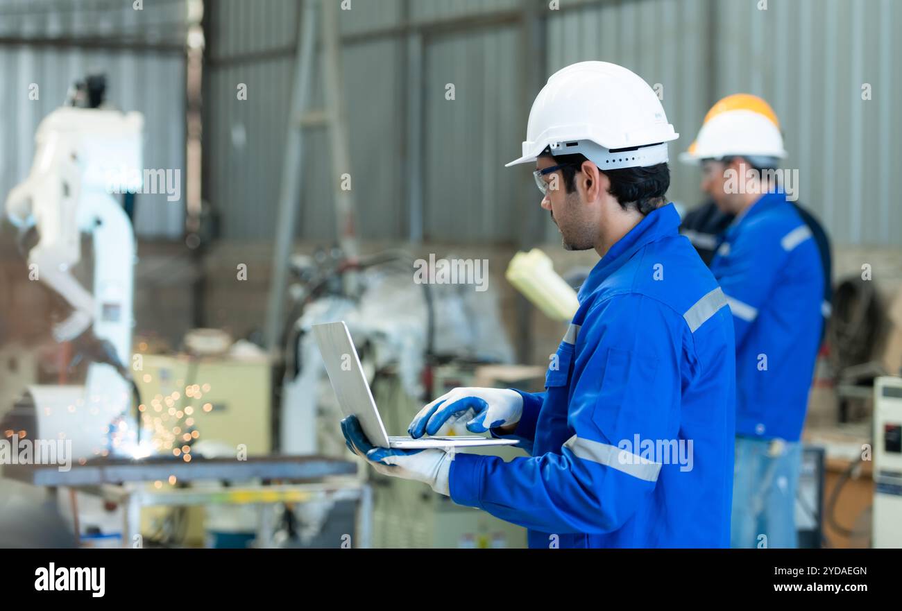 Group of engineers are manipulating a welding robot hand. By combining ...