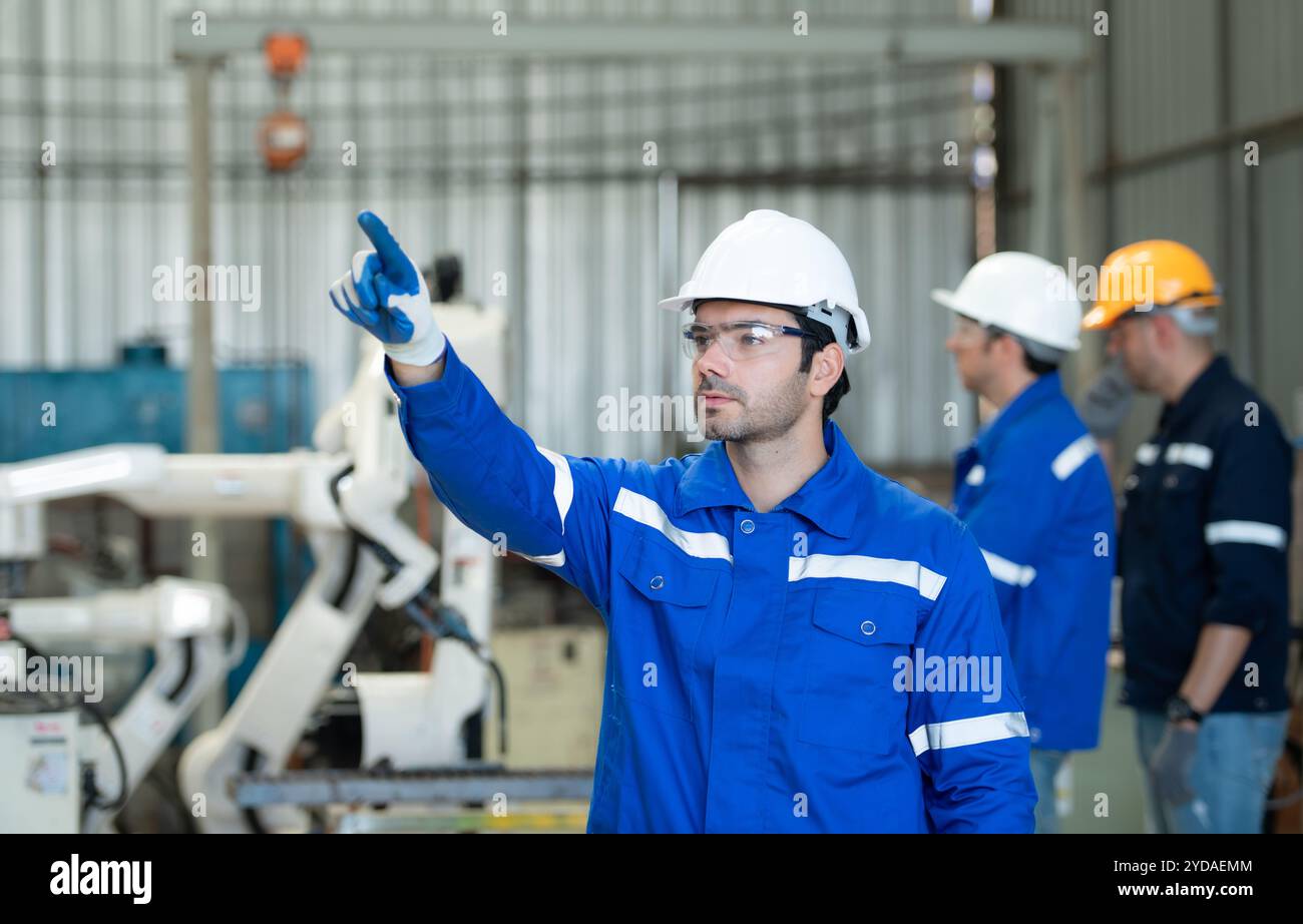 Group of engineers are manipulating a welding robot hand. By combining ...