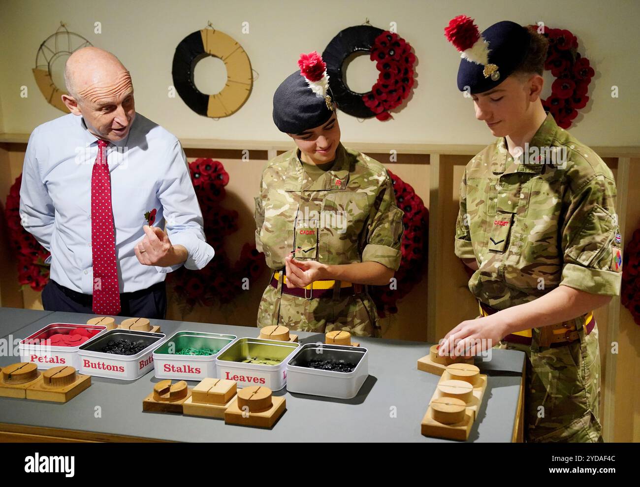 British Defense Secretary John Healey, left, makes poppies with cadets ...