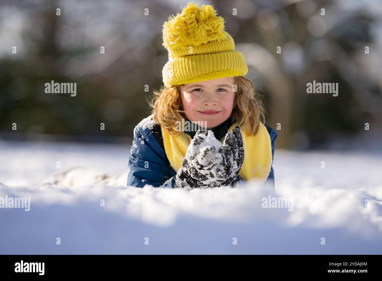 Happy teen child playing with snow during snowfall. Child in winter ...