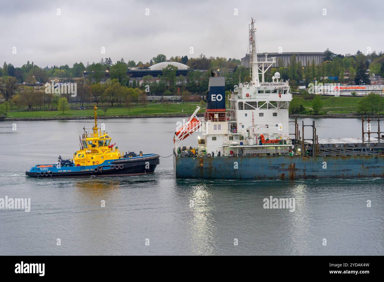 Vancouver, BC, Canada - April 26, 2024: A tugboat guiding a empty cargo ...