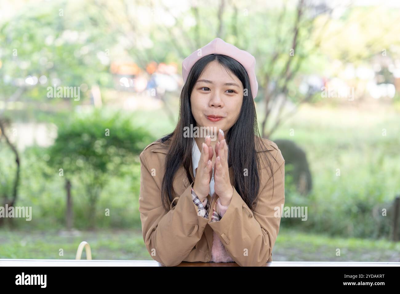 A long-haired Taiwanese woman in her 20s wearing a brown trench coat ...