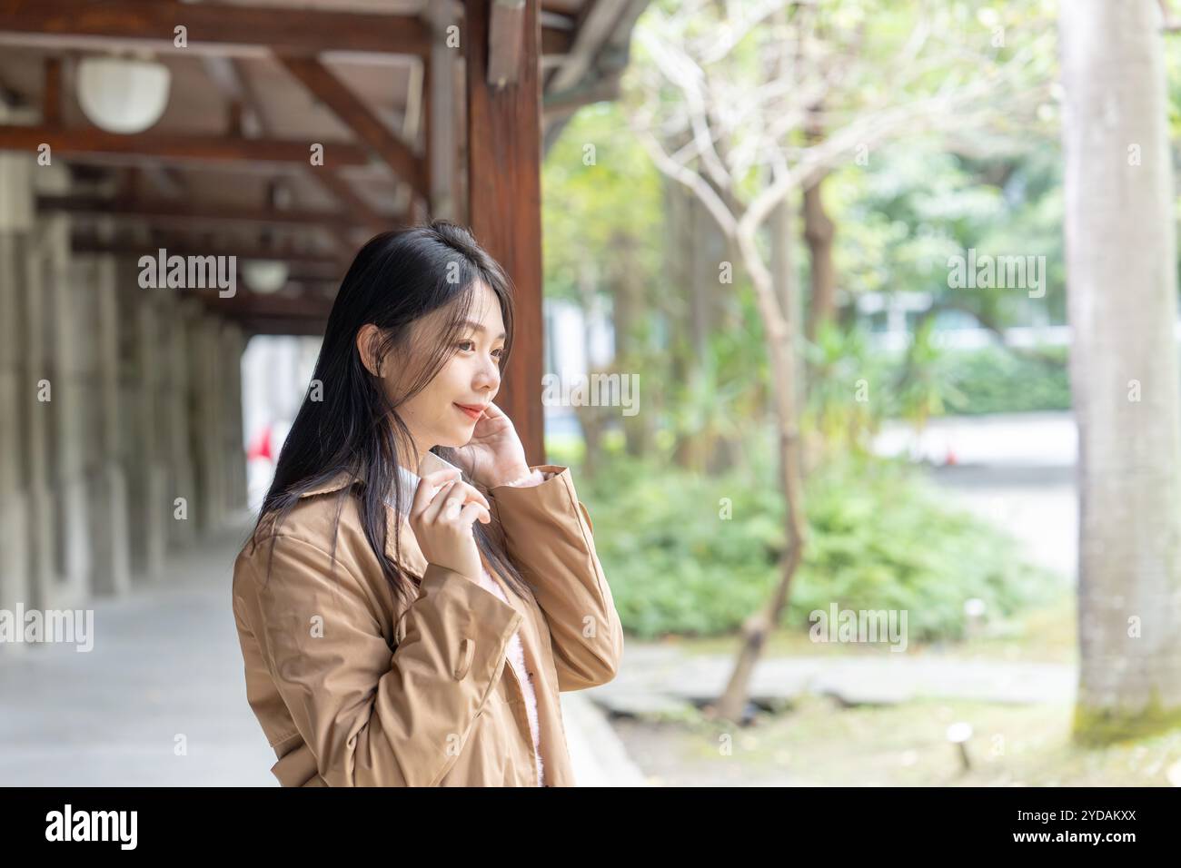 A long-haired Taiwanese woman in her 20s wearing a beige trench coat ...