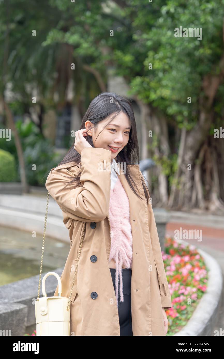 A long-haired Taiwanese woman in her 20s wearing a beige trench coat ...