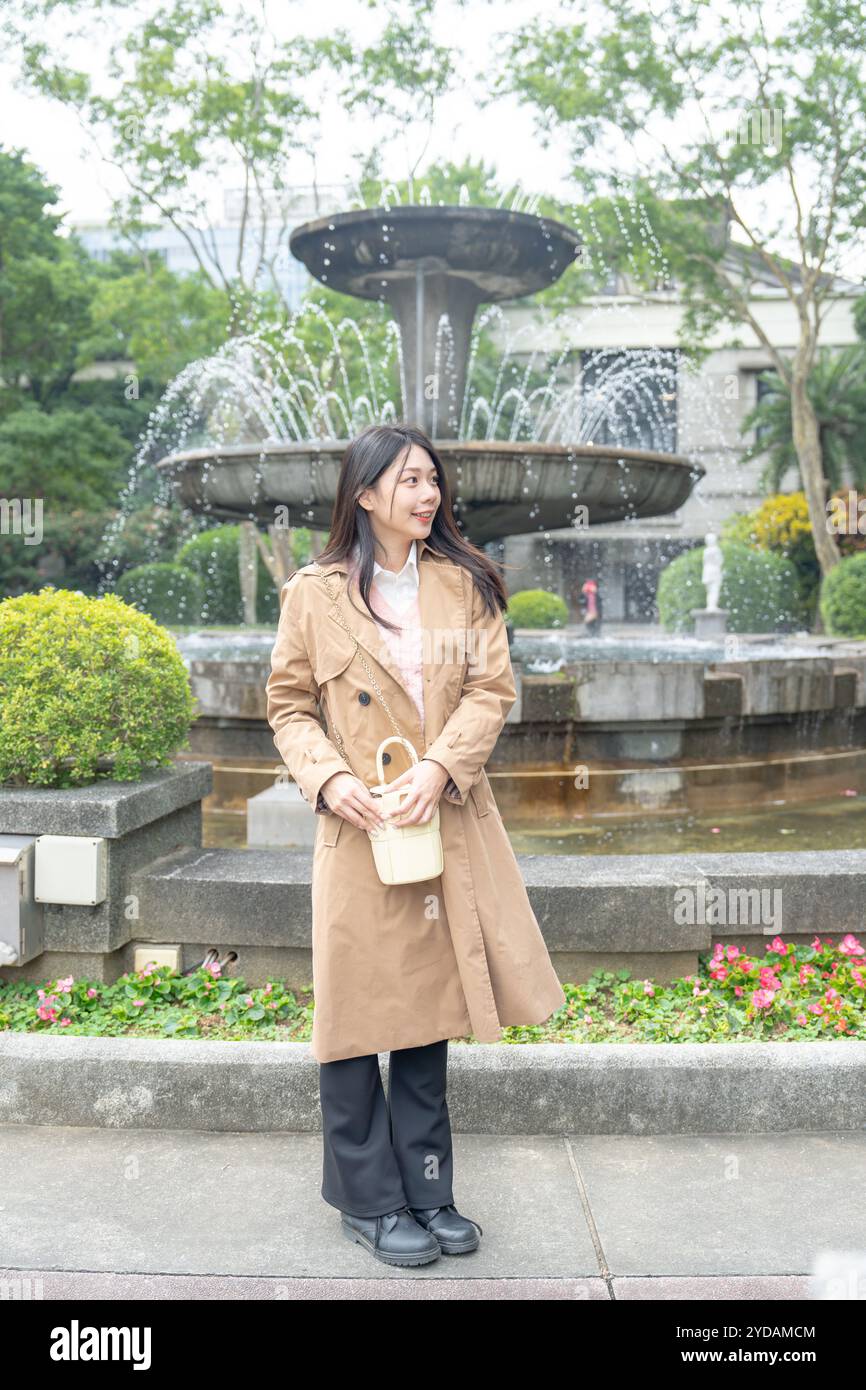 A long-haired Taiwanese woman in her 20s wearing a beige trench coat ...