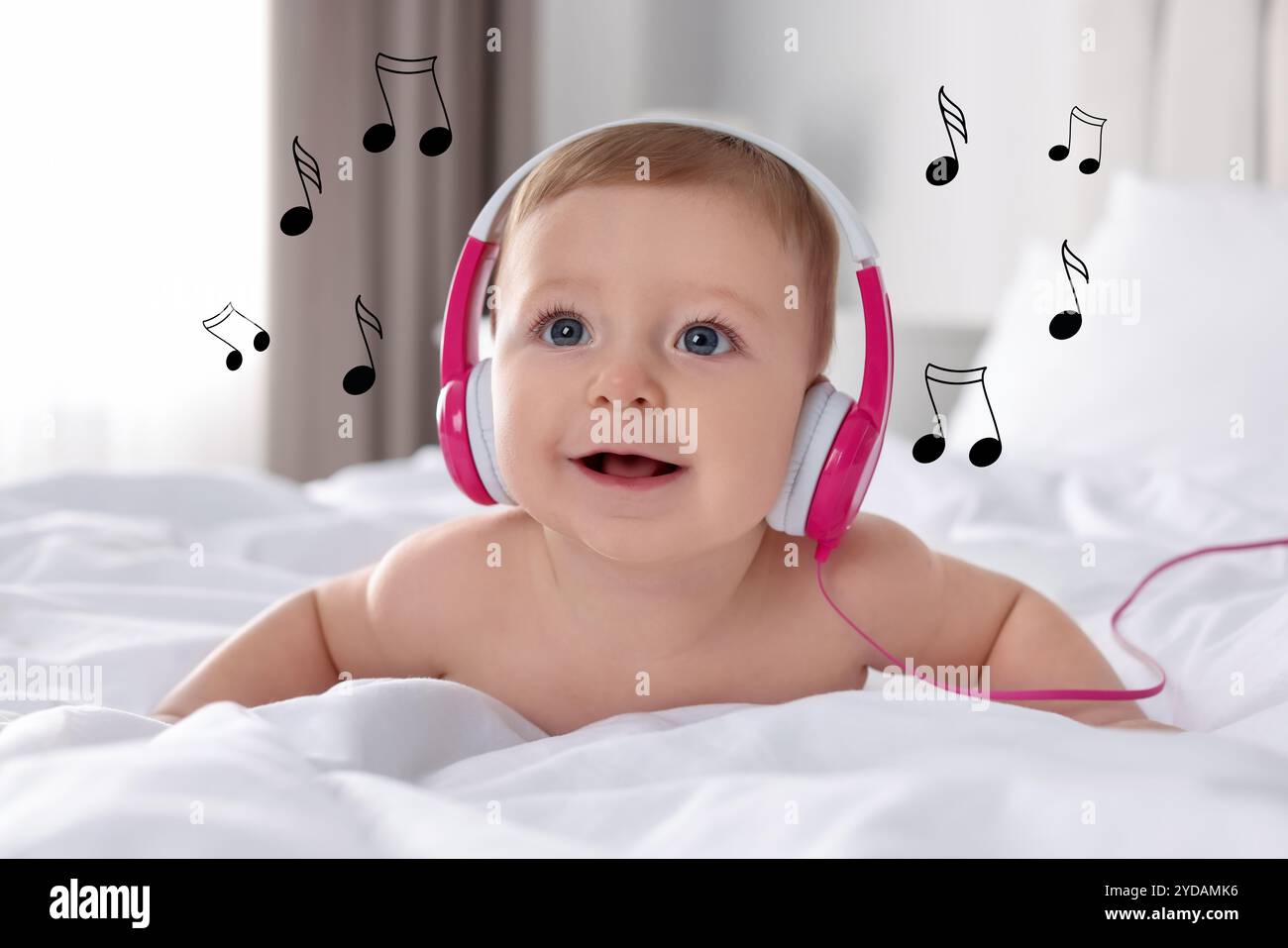 Cute little baby with headphones on bed at home. Music notes flying ...