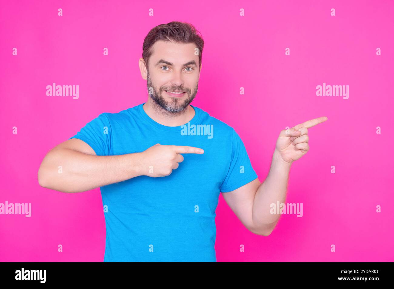 Copy space pointing. The point away. Happy handsome man pointing finger ...