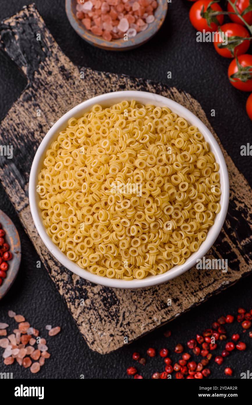 Raw anellini pasta from durum wheat with salt and spices on a dark ...
