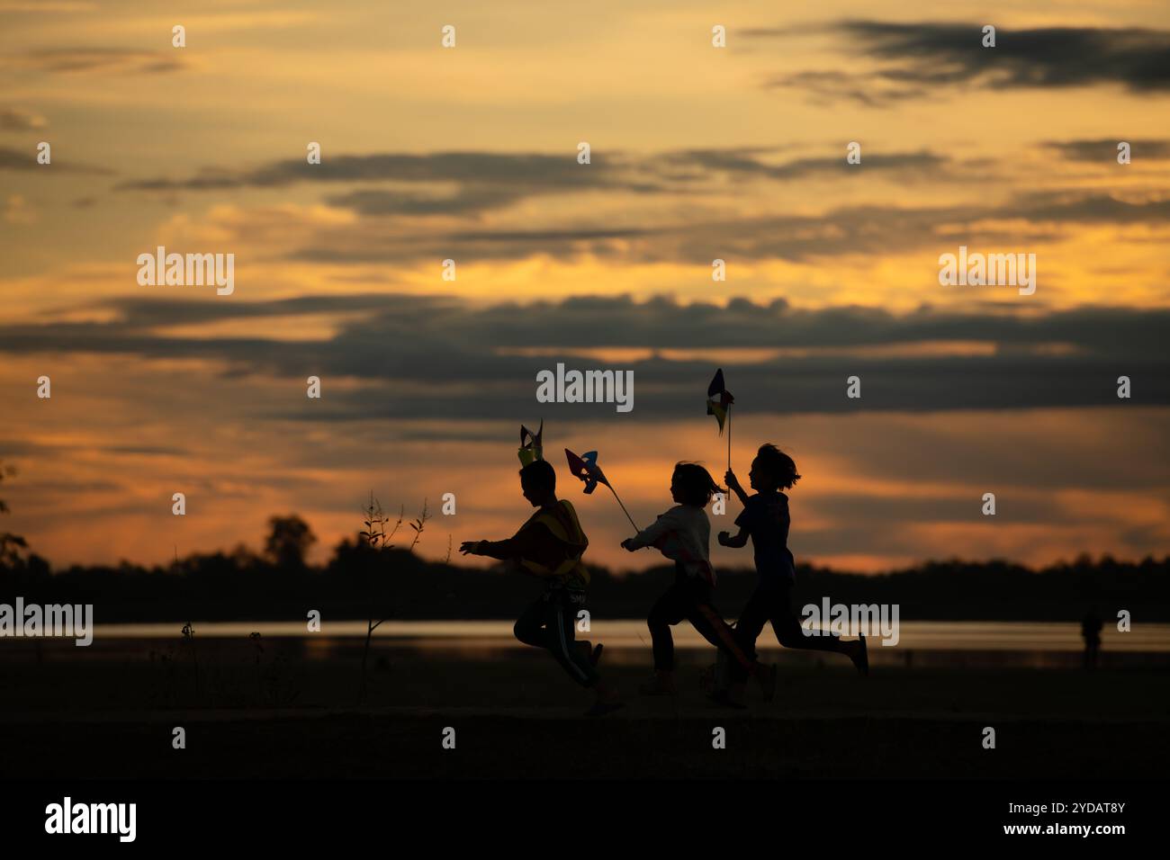 Children riding bicycles and running In the early light of the day as ...