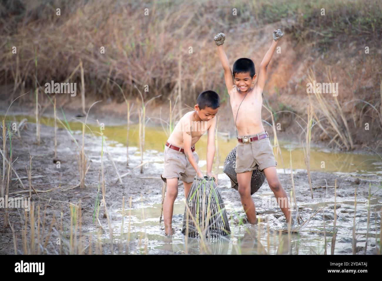 After class, little boys in rural Thailand like catching fish in the ...