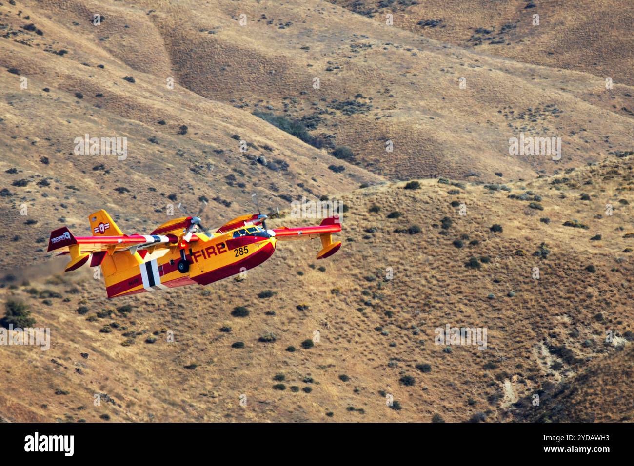 Firefighter Aircraft Battling Wildfire in Arid Terrain Stock Photo - Alamy