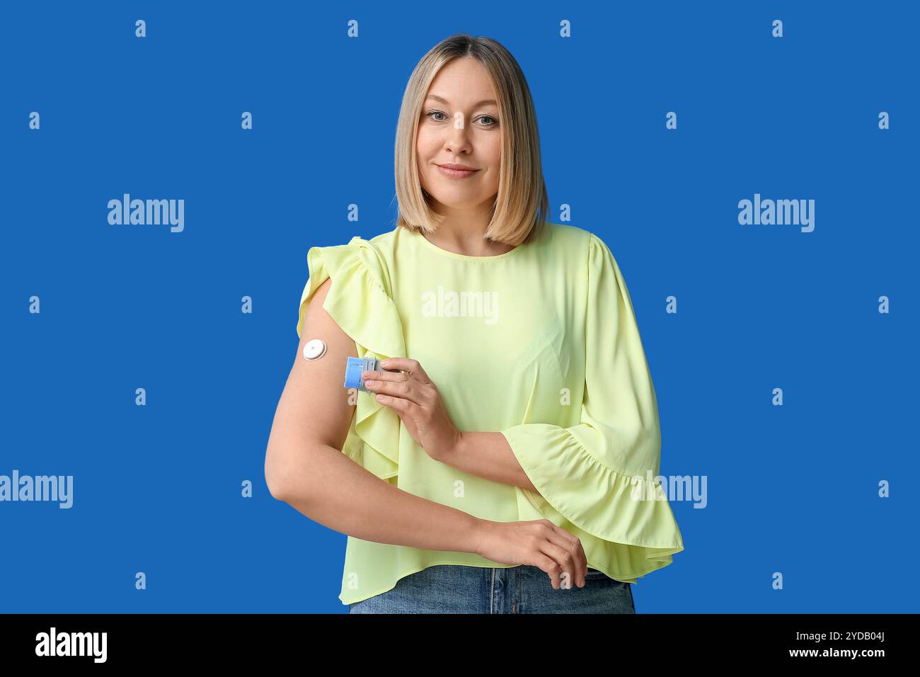 Woman with glucose sensor for measuring blood sugar level and ...