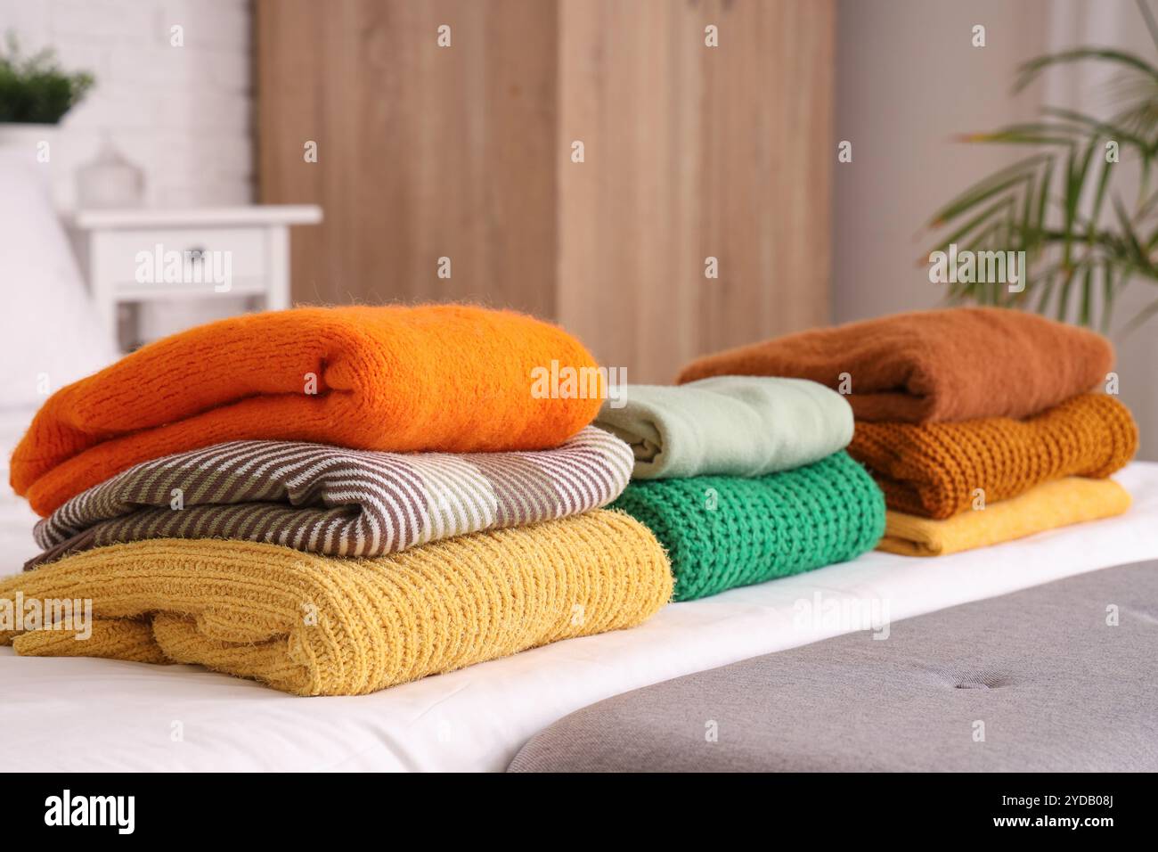 Folded clean clothes on bed at home Stock Photo - Alamy
