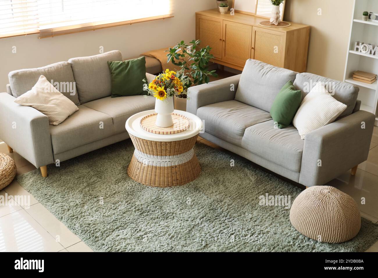Comfortable sofas and wild flowers in vase on coffee table in interior ...