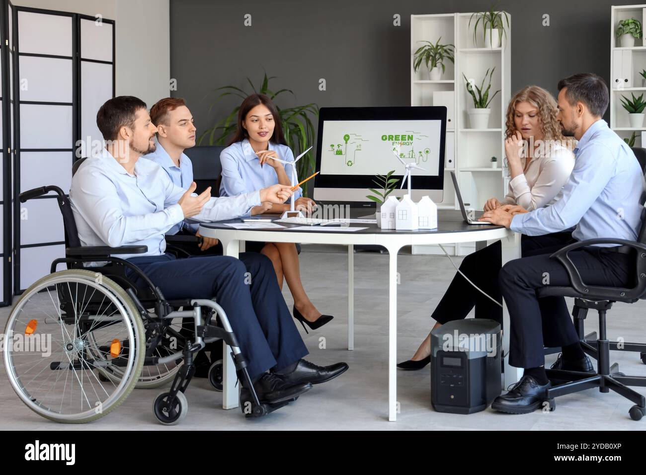 Business people with computer at table during meeting in office. Green ...