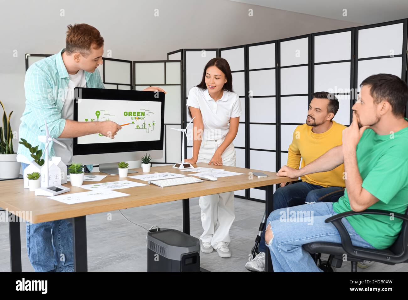 Colleagues with computer having business meeting at table in office ...