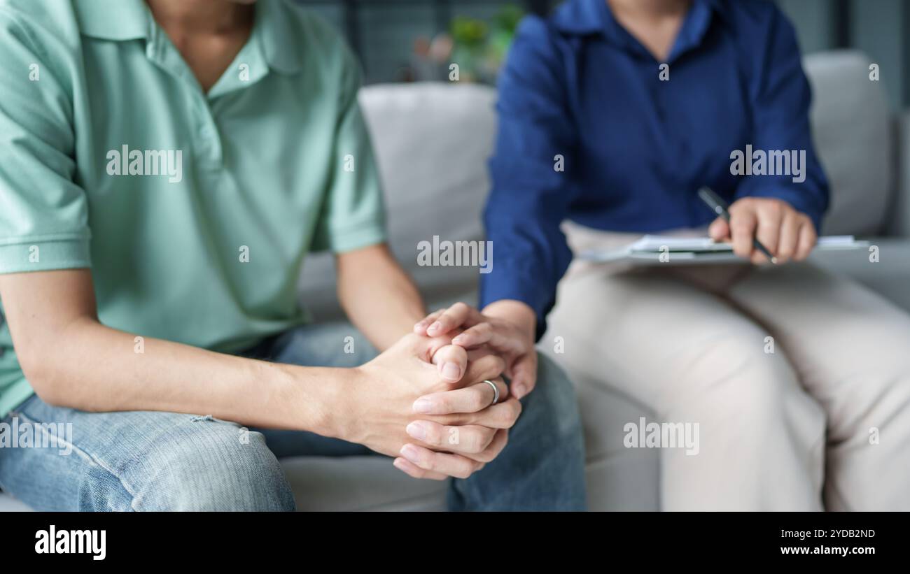 Sad male sitting onÂ sofa Patient discussing mental health issues with ...