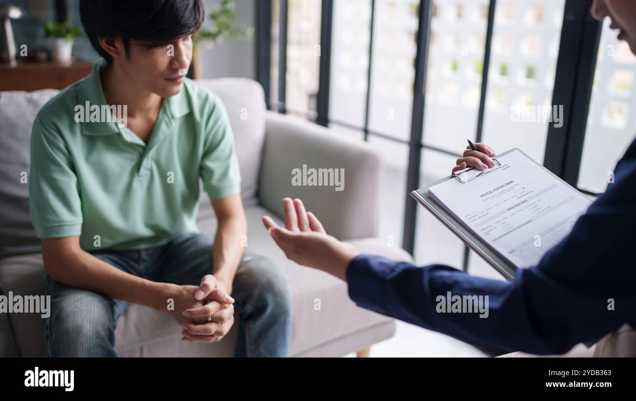 Sad male sitting onÂ sofa Patient discussing mental health issues with ...