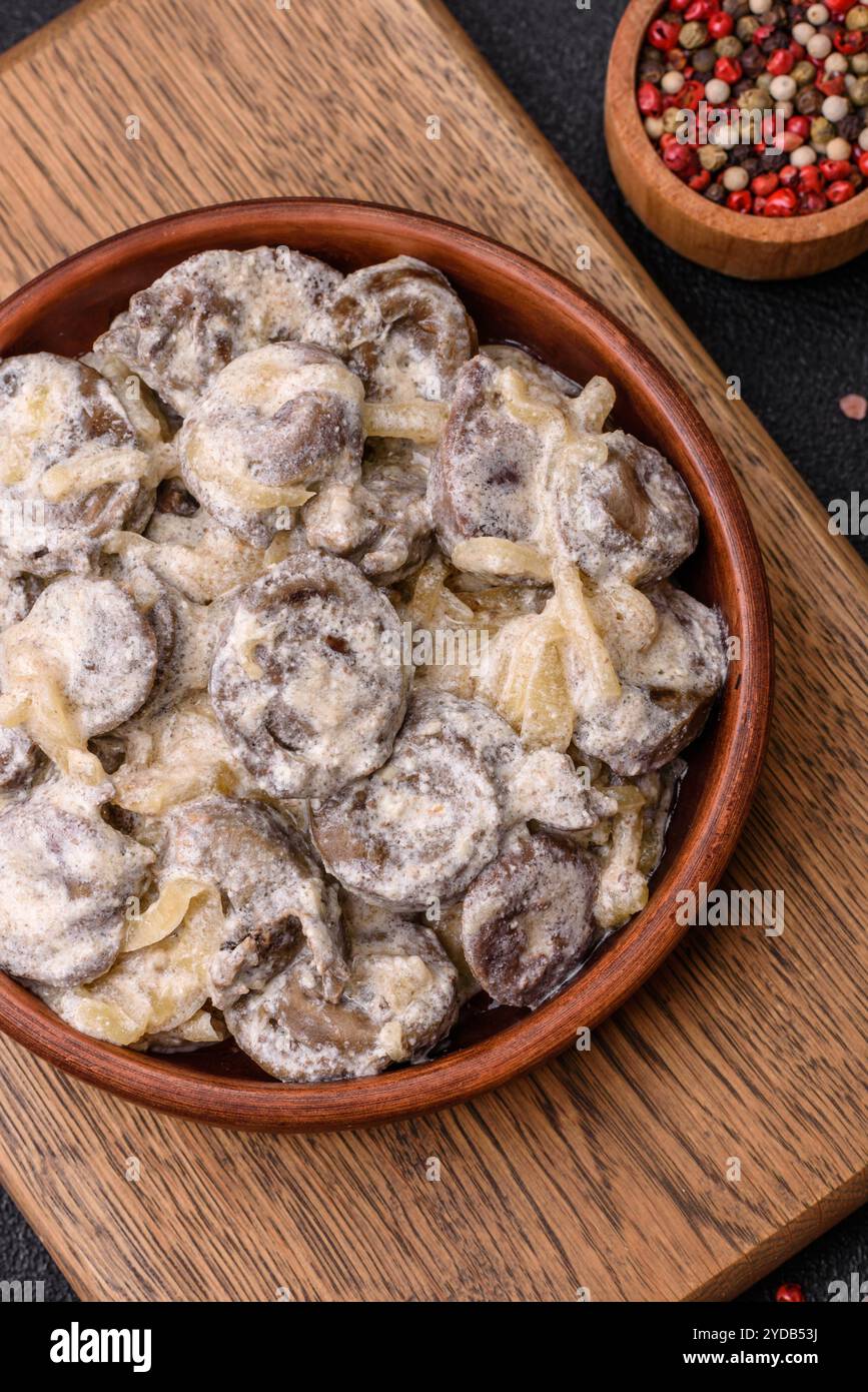 Boiled chicken hearts cut into slices with onions and cream sauce Stock ...