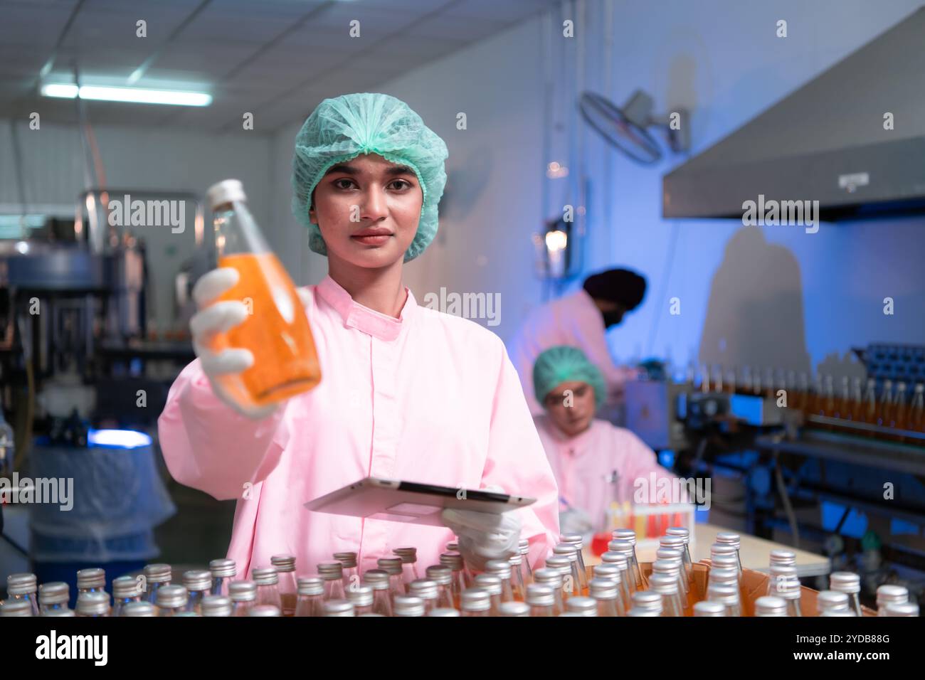 Product quality control staff at the fruit juice production line ...