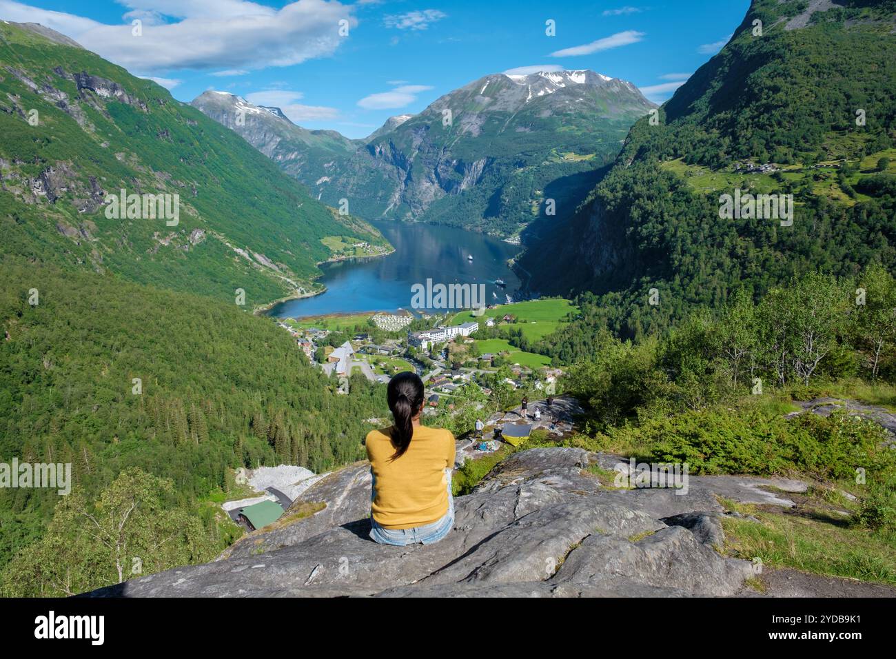 A woman sits on a rocky ledge overlooking a breathtaking Norwegian ...