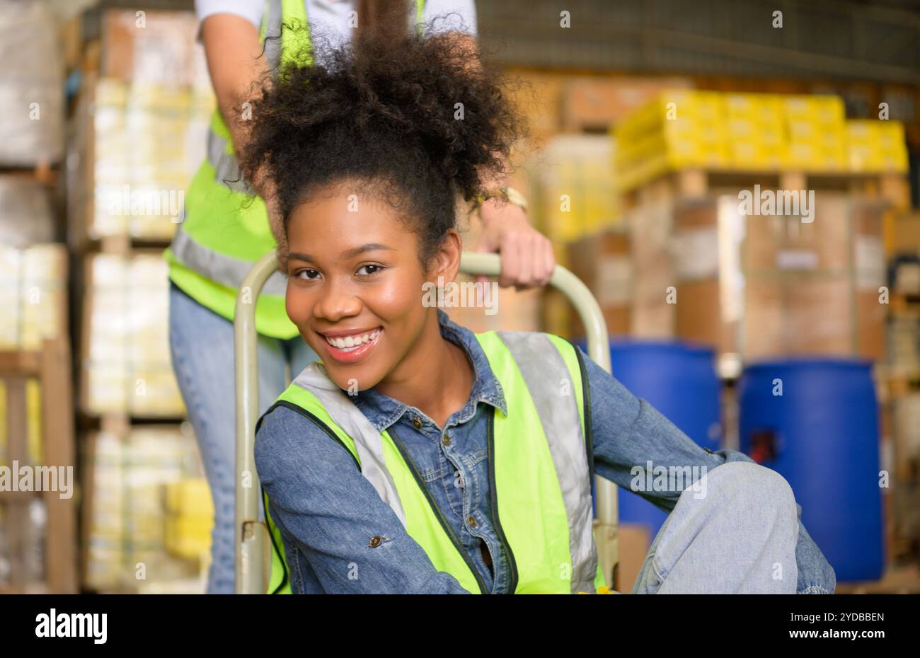Two girls warehouse workers relax and play during the break of the day ...