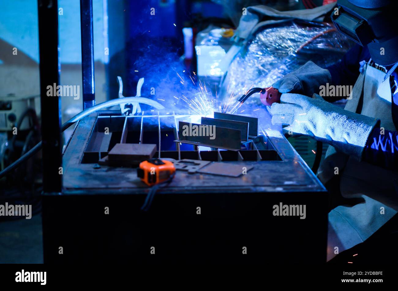 A welder is working to weld metal. to create quality work according to ...