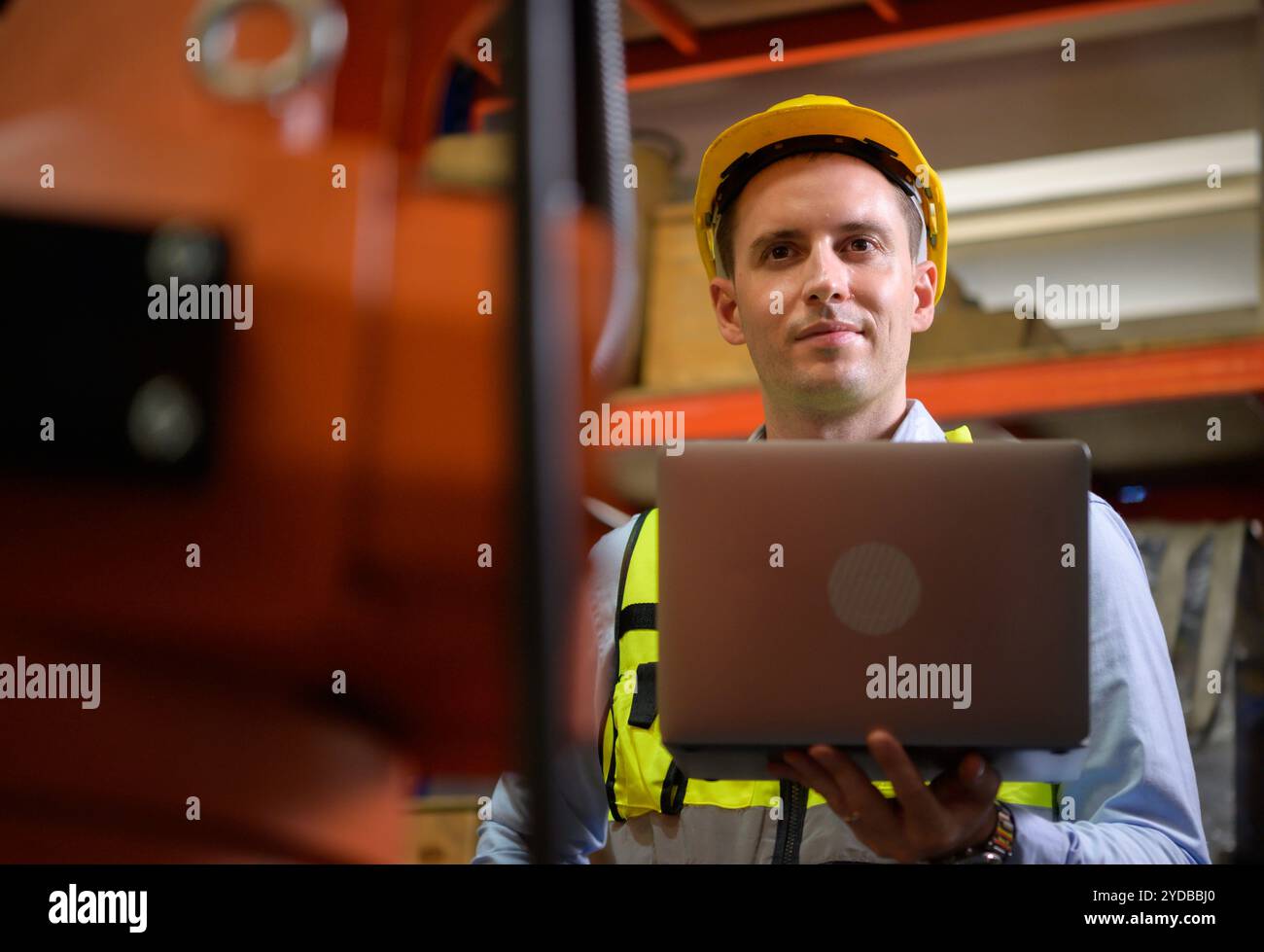 A male engineer checking the operation of a welding robot. used for ...