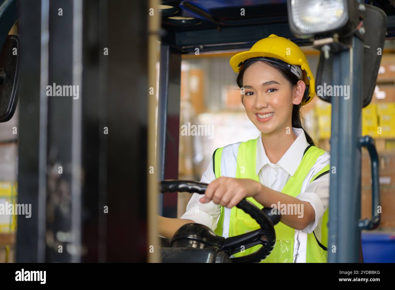 Female worker driving a forklift moving goods in the warehouse ...