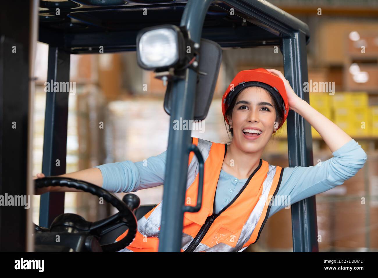 Portrait of an Asian woman with a forklift used to lift heavy objects ...