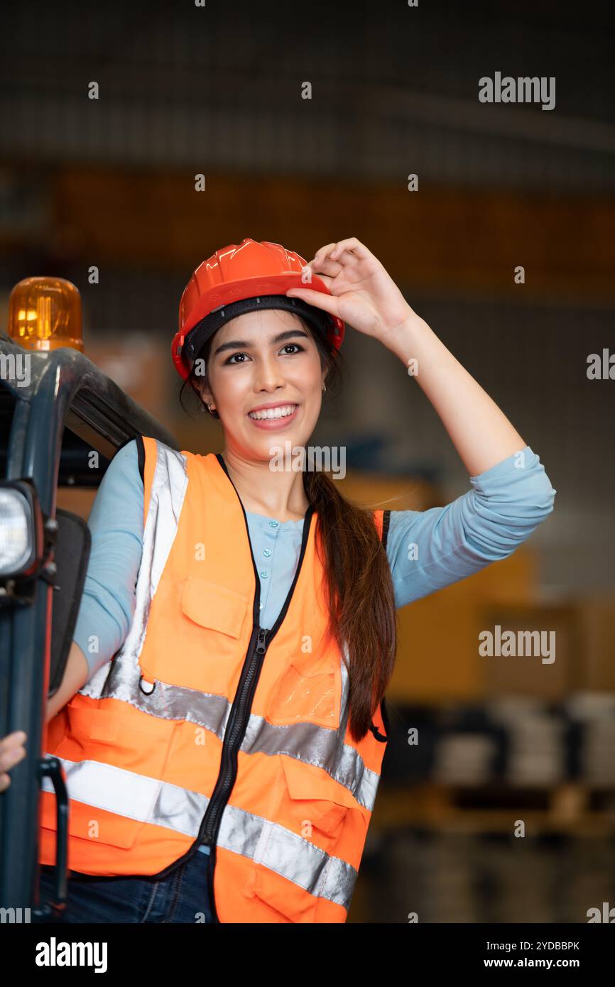 Portrait of an Asian woman with a forklift used to lift heavy objects ...