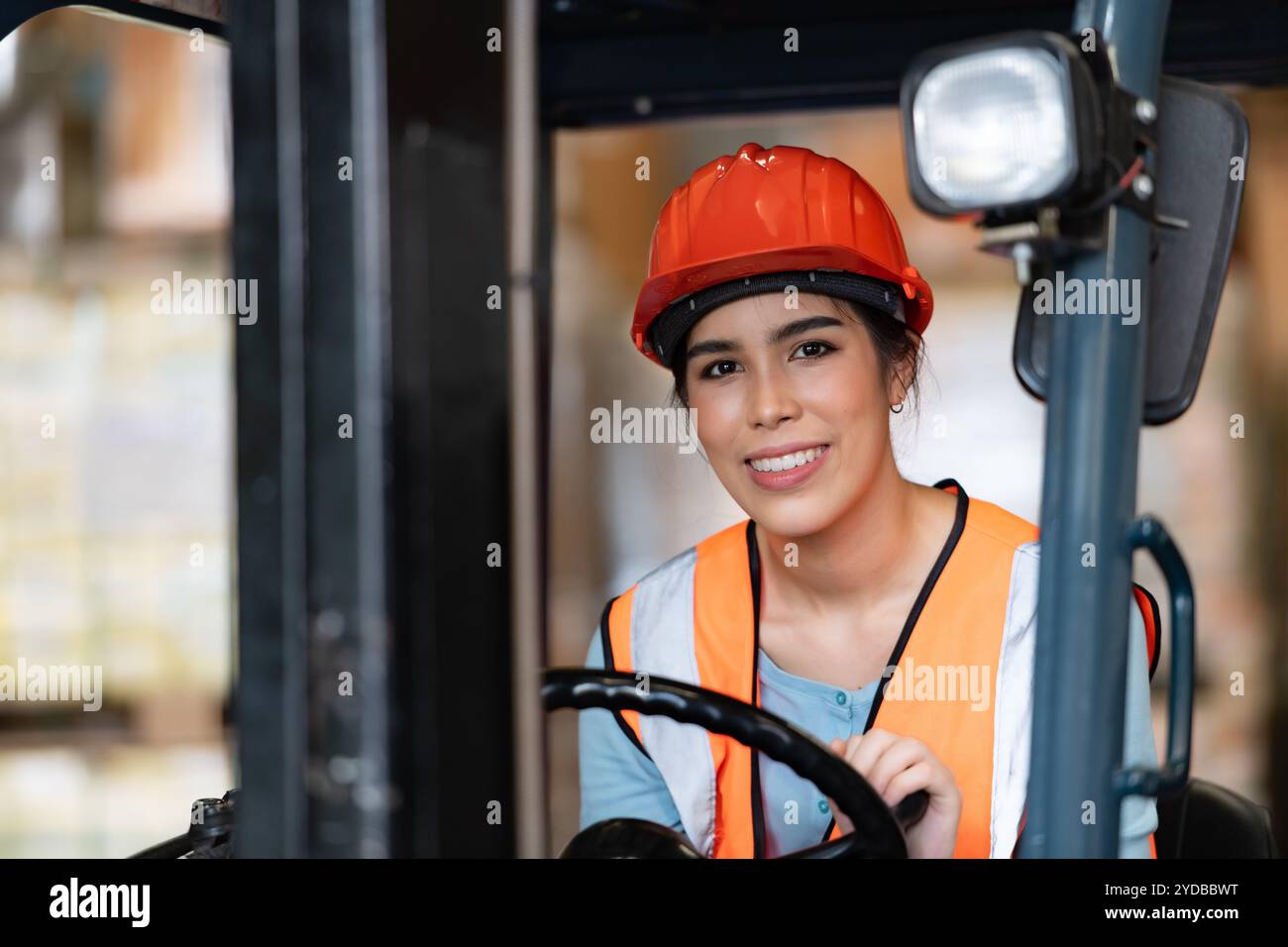 Portrait of an Asian woman with a forklift used to lift heavy objects ...