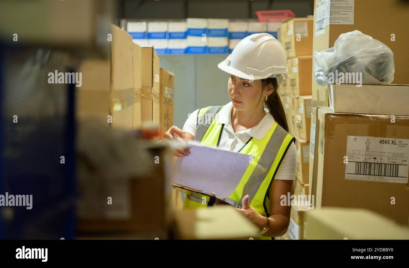 Female warehouse worker Counting items in an industrial warehouse on ...