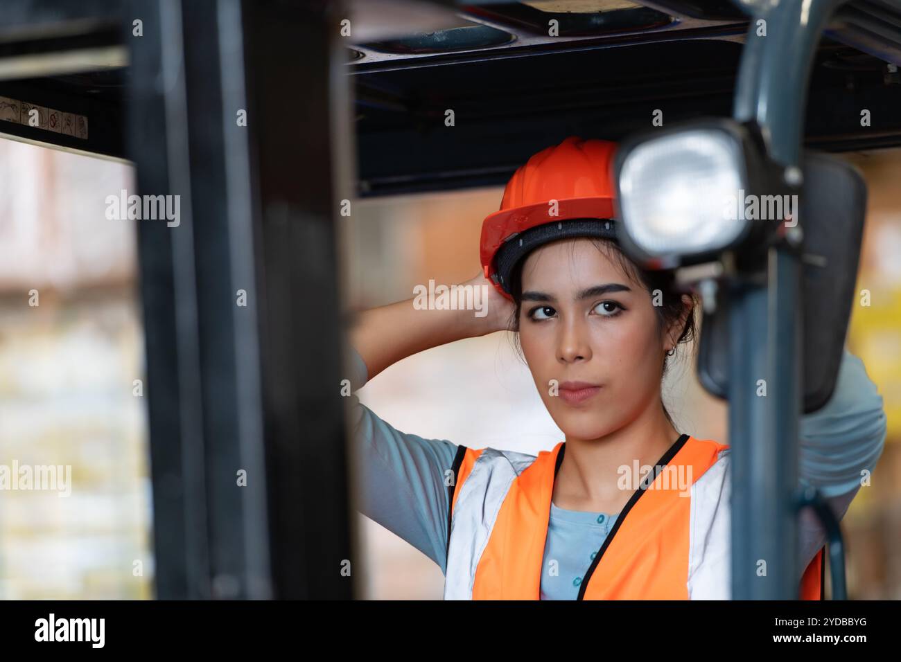 Portrait of an Asian woman with a forklift used to lift heavy objects ...