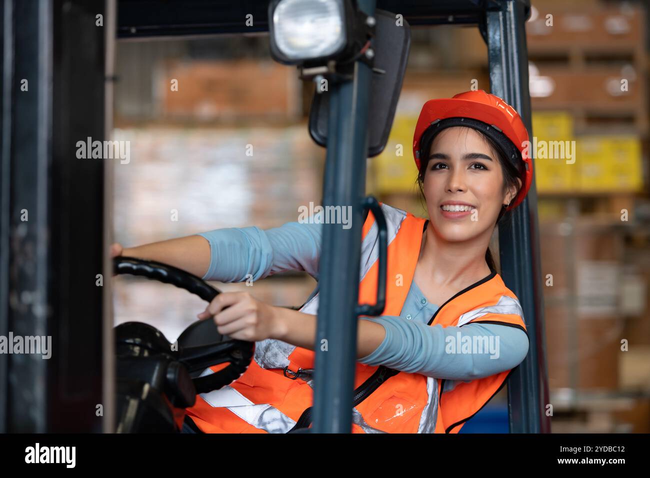 Portrait of an Asian woman with a forklift used to lift heavy objects ...