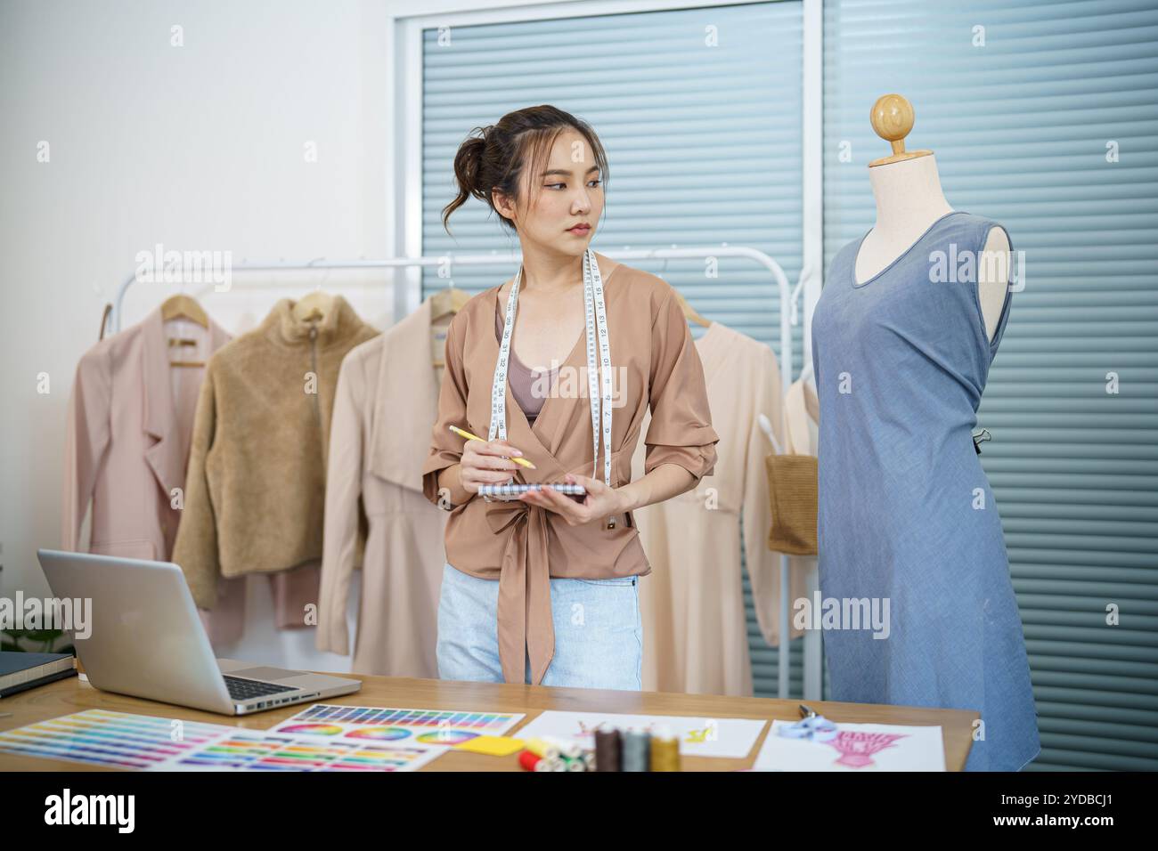 Stylish Fashion Designer work as sketch of new collection in atelier ...