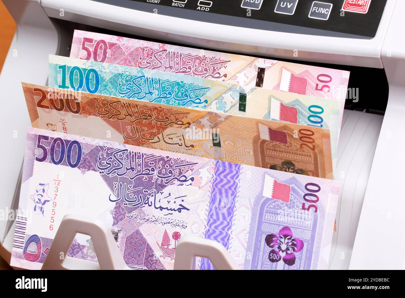 Qatari riyal in the counting machine Stock Photo - Alamy