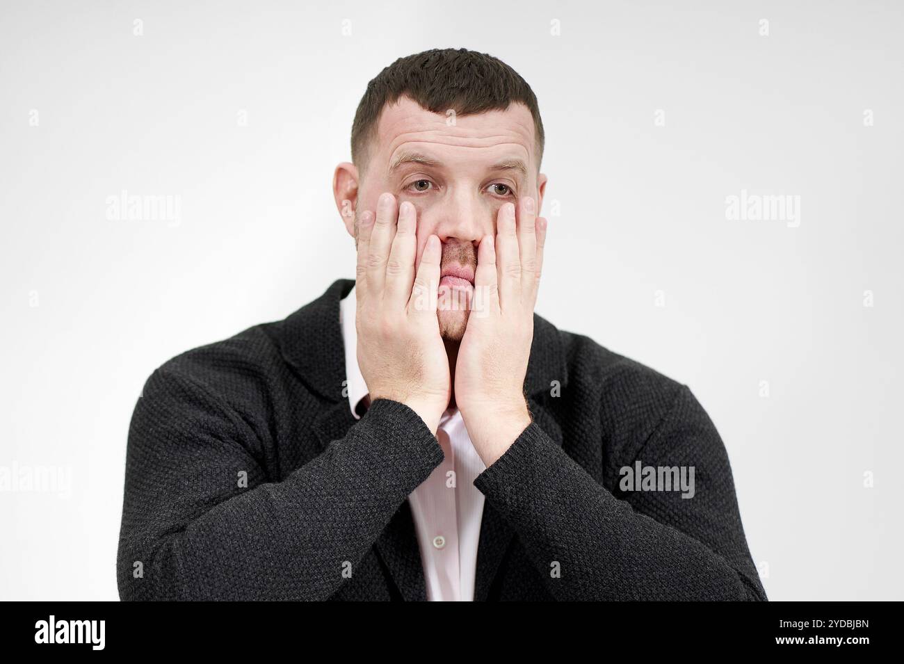 Stressed businessman with hands on the face over grey background with ...