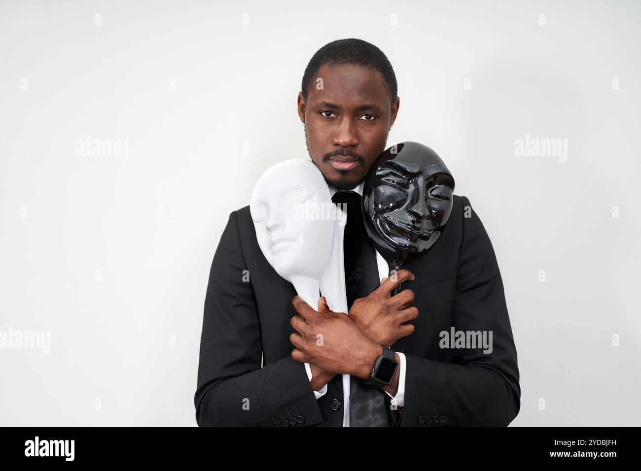 African young man wearing black suit holding white and black plastic ...