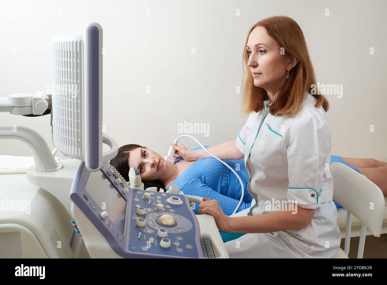 Doctor using ultrasound scanning machine examining female neck Stock ...