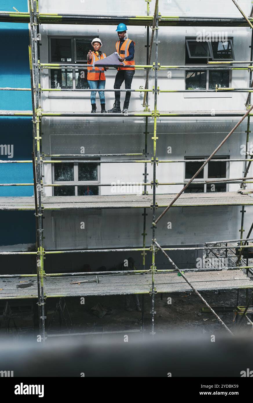 Blueprint, man and woman on construction scaffolding with planning, collaboration and urban ...