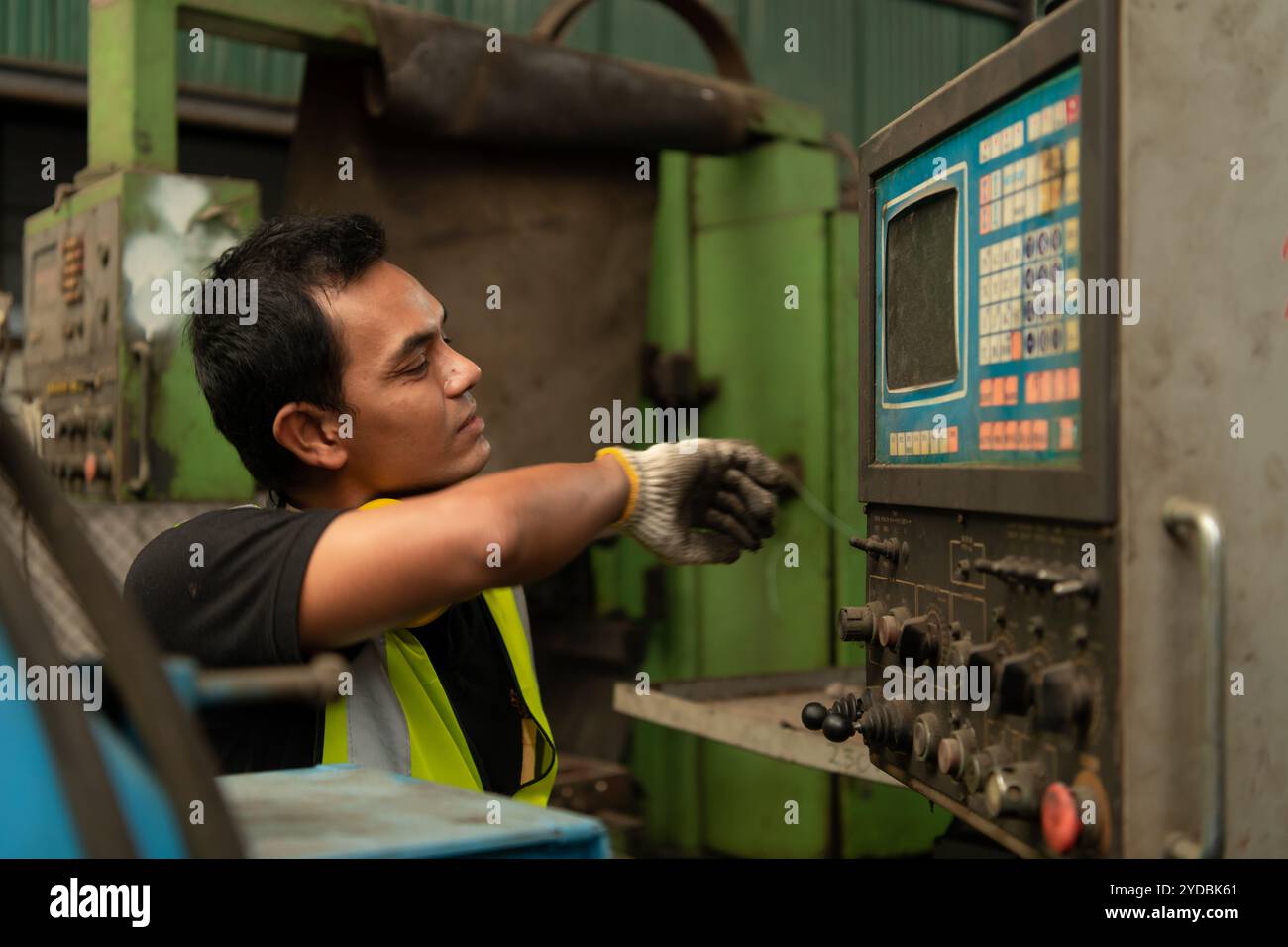 Asian mechanic working in a mechanical factory Repairing old machines ...