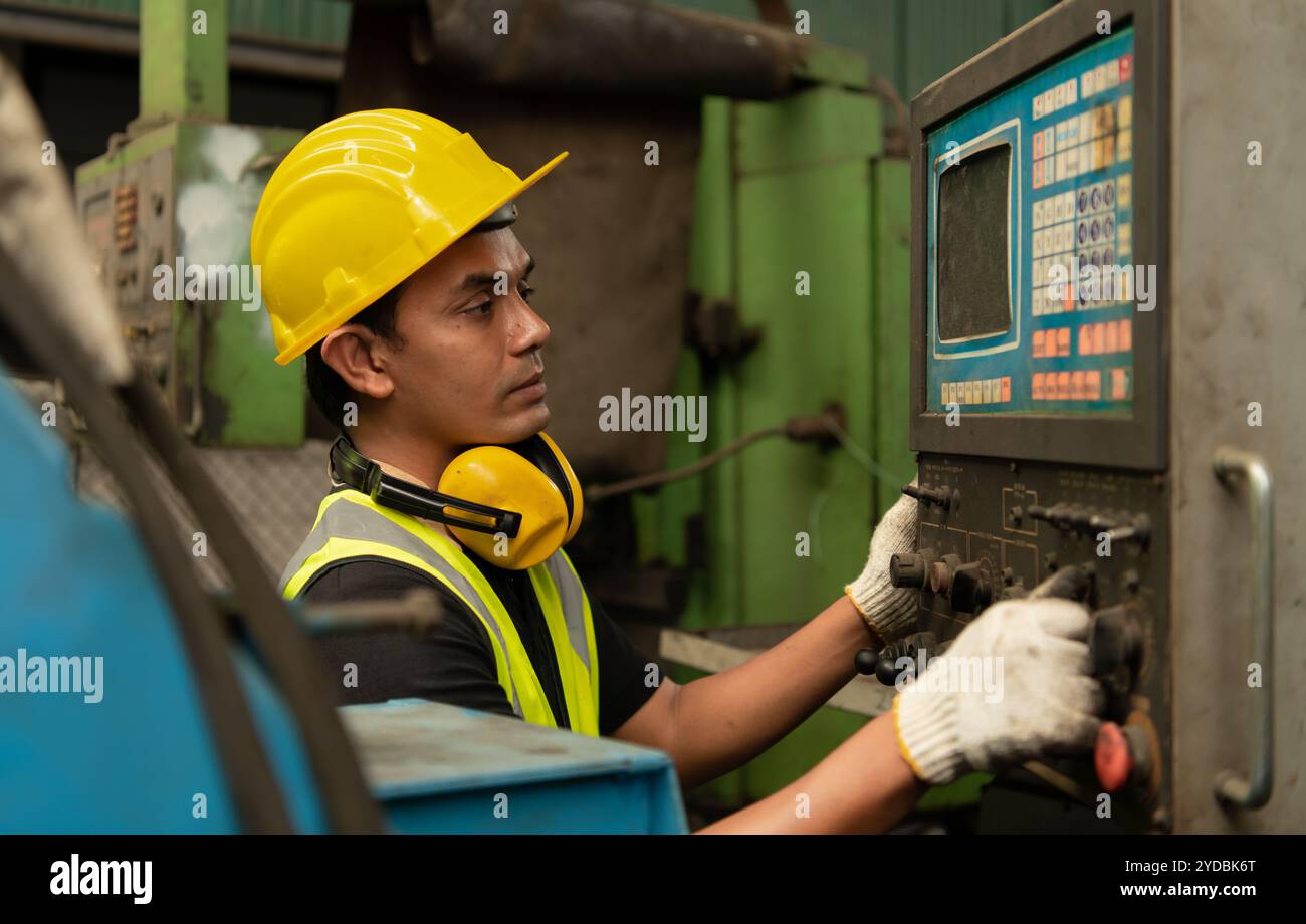 Asian mechanic working in a mechanical factory Repairing old machines ...